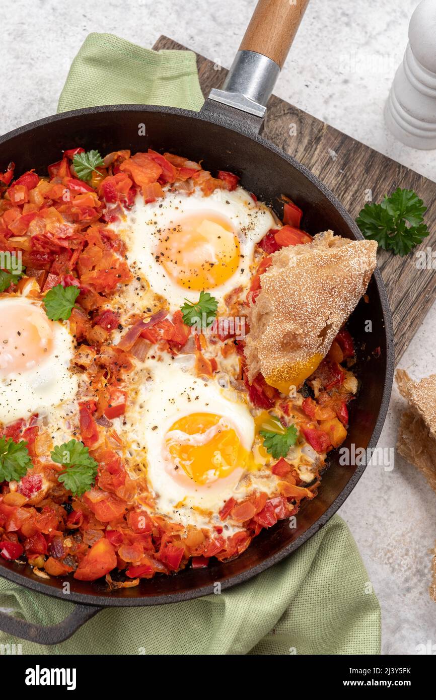 Shakshouka, eggs poached in sauce of tomatoes Stock Photo - Alamy