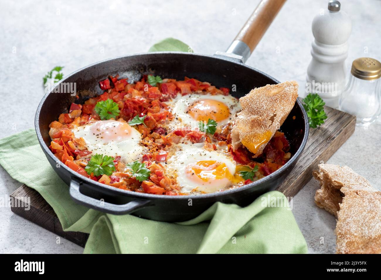 Shakshouka, eggs poached in sauce of tomatoes Stock Photo - Alamy