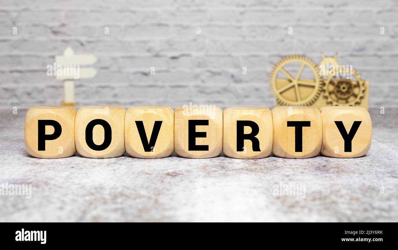 Poverty word written on wood block. Poverty text on wooden table for ...