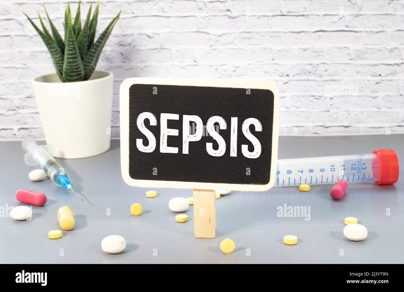 Text sepsis on white background. There are various pills and vitamins ...