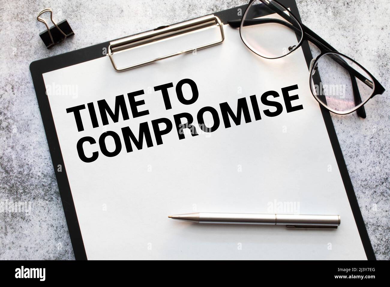 Businessman holds a card with text TIME TO COMPROMISE Stock Photo - Alamy