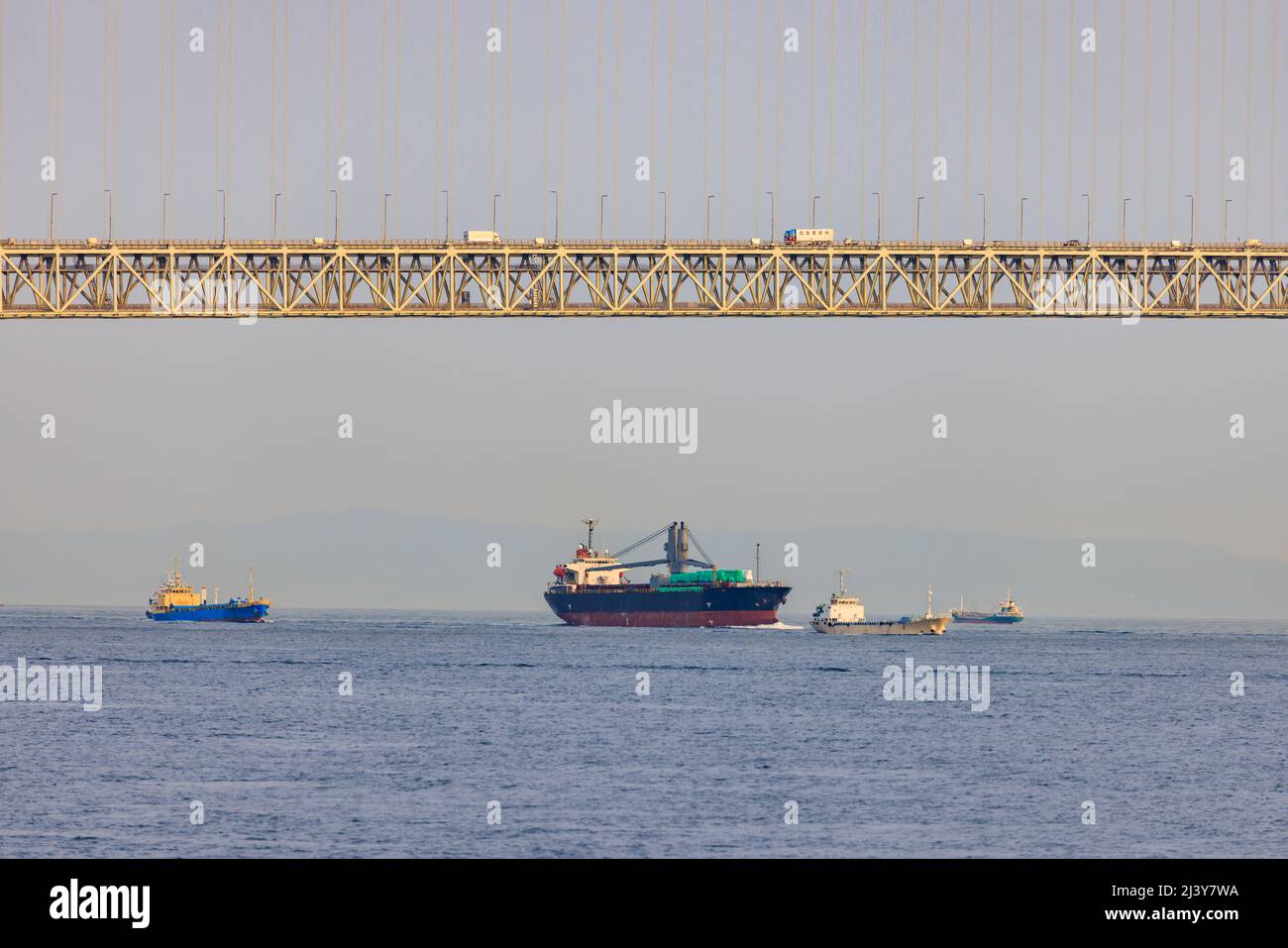 Cargo ships cross under bridge span Stock Photo - Alamy