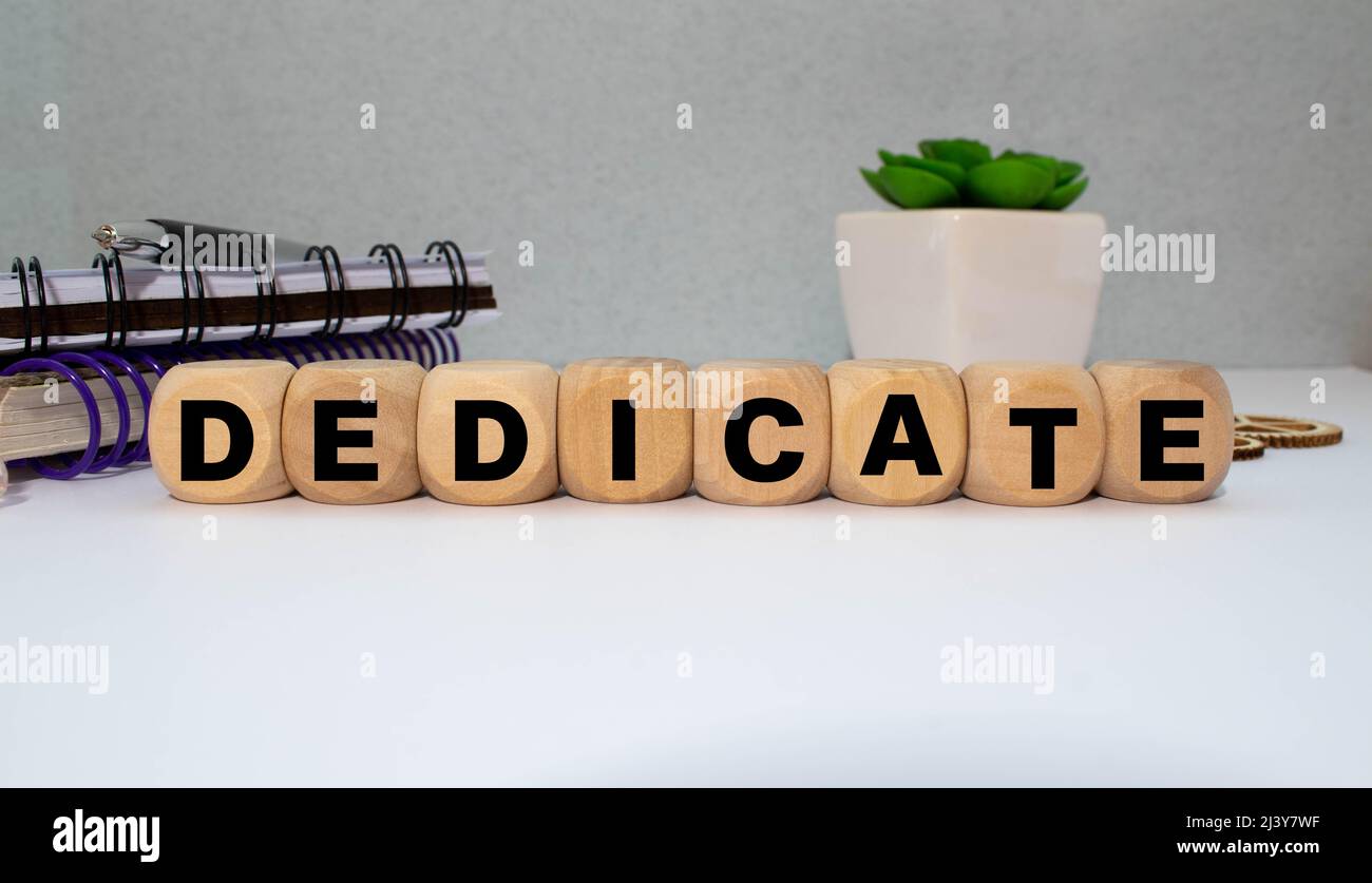 Word Dedicate on a row of wooden blocks. Devotion dedication love concept Stock Photo - Alamy