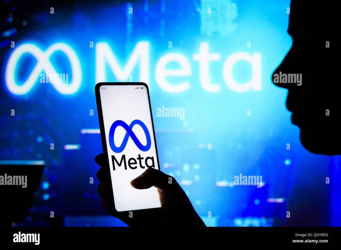 In this photo illustration, a woman holds a smartphone with the Meta Platforms, Inc. logo ...