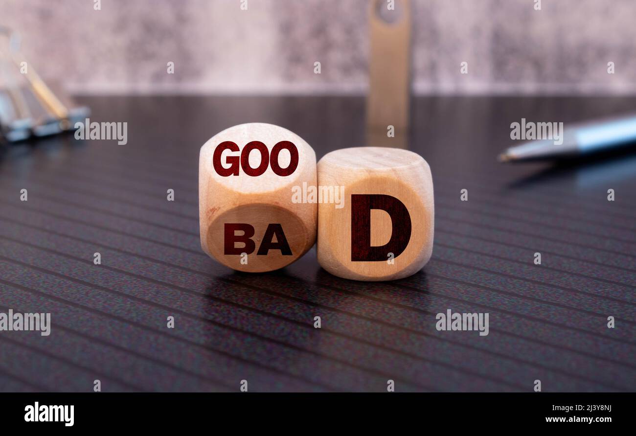 Good or bad symbol. Businessman hand turns a cube and changes the word ...