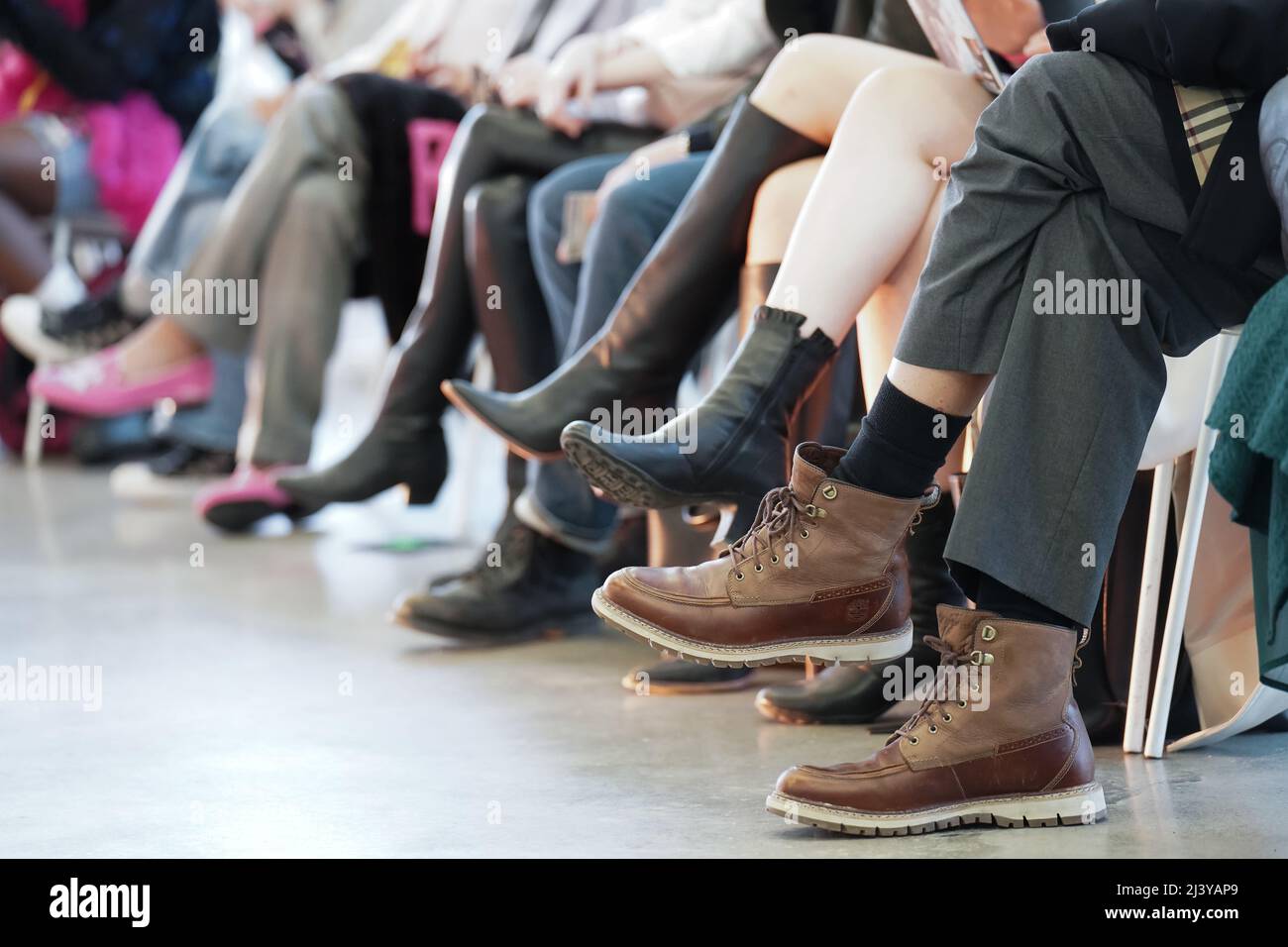 anonymous people sitting down only feet are showing Stock Photo - Alamy