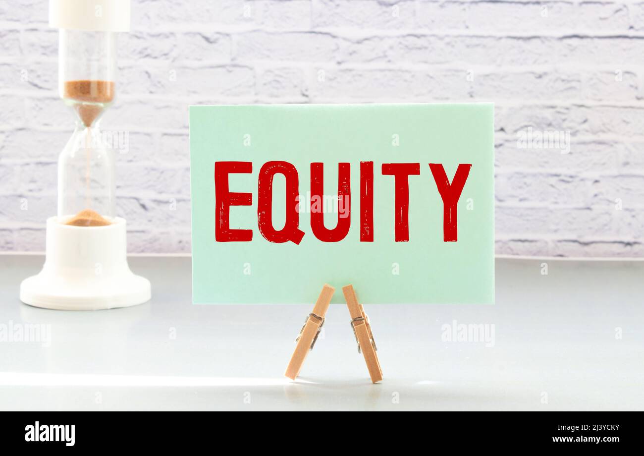 Word Equity on mini chalkboard and coin in the jar with blurred ...