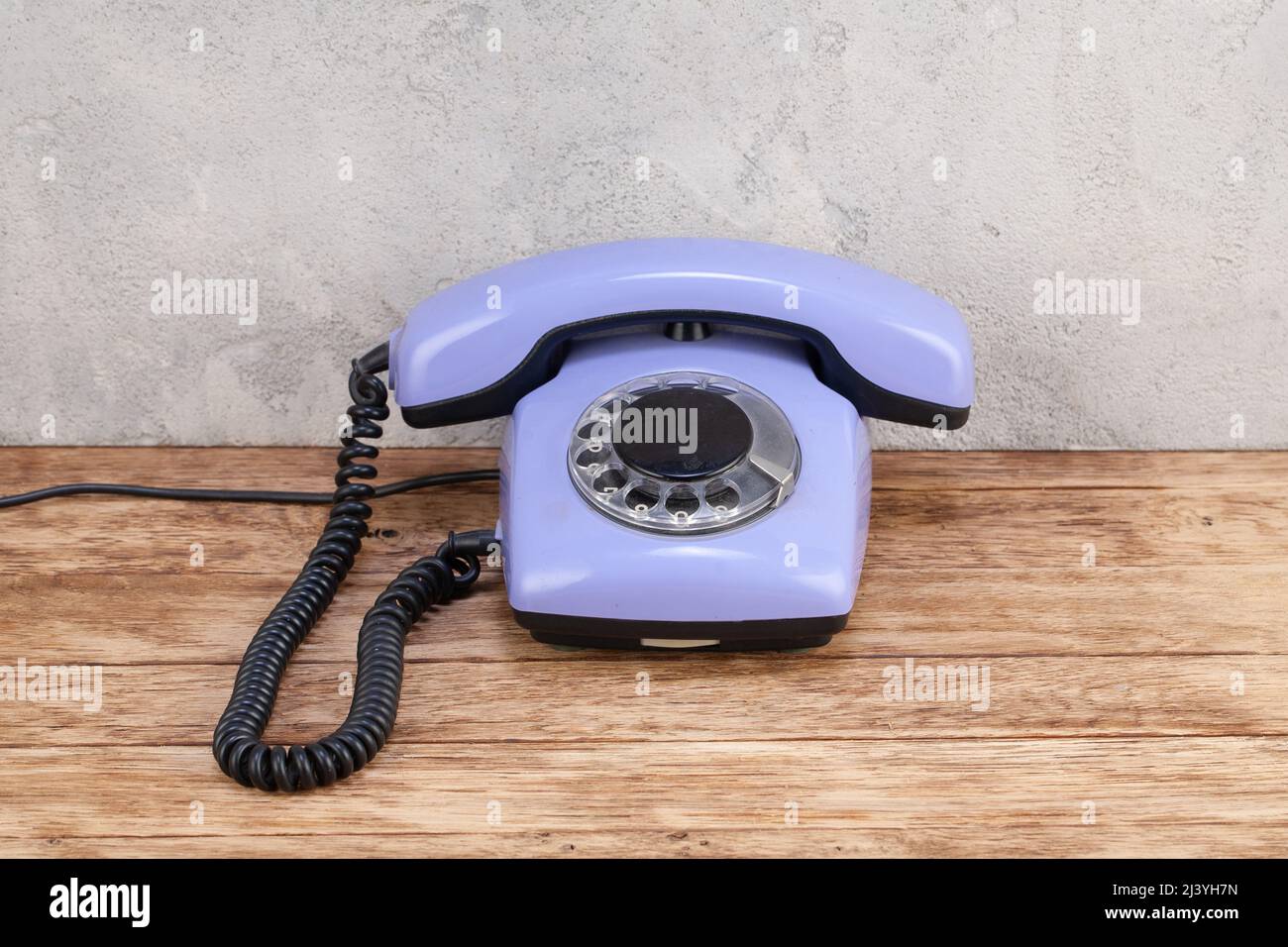 Vintage blue rotary dial telephone on wooden table in front gray ...