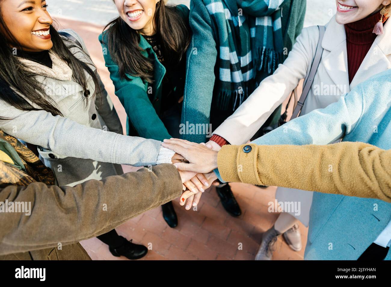 Multiracial business people stacking hands while celebrating together ...