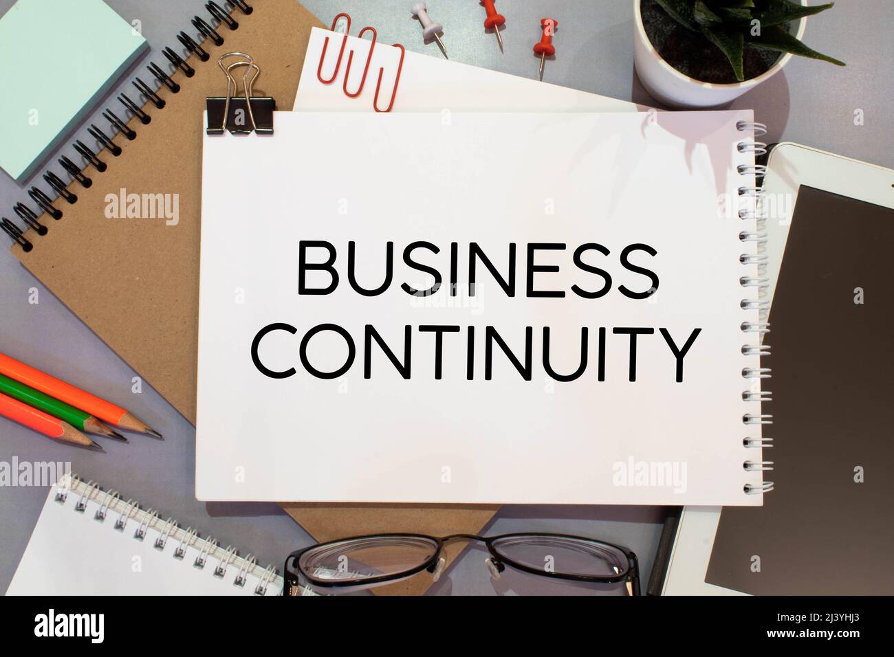 Stickers on notebook text BUSINESS CONTINUITY with pen and glasses on ...