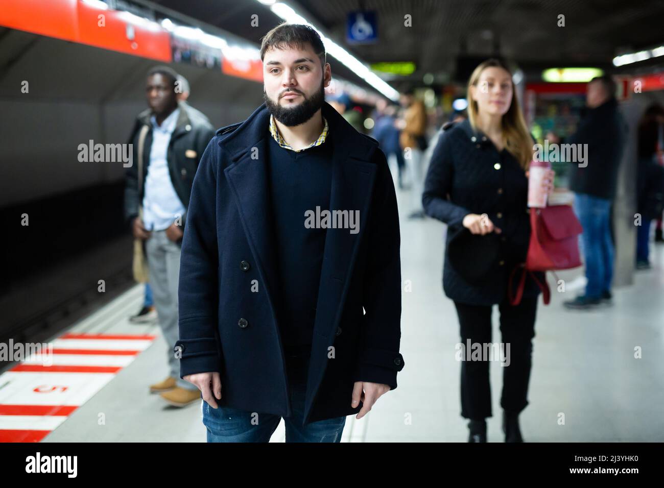 Young man waiting for subway train Stock Photo - Alamy