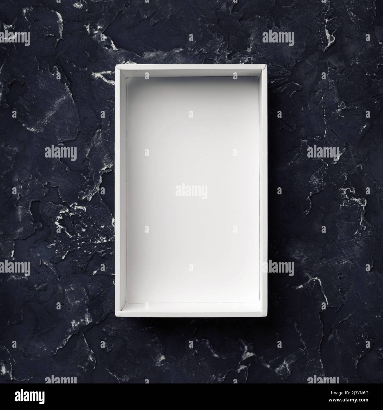 Blank package mockup. White paper box on black plaster background. Top ...