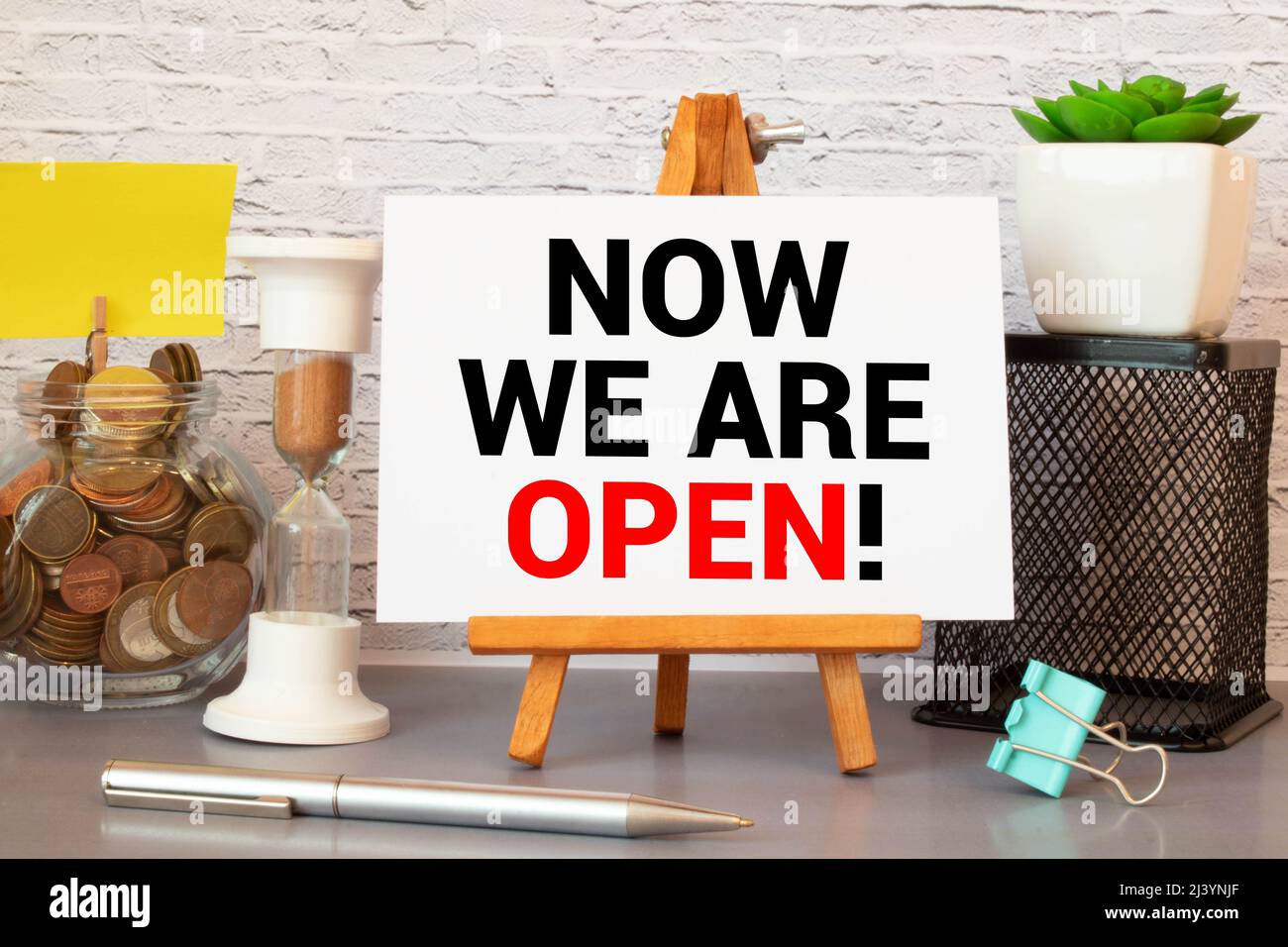 NOW OPEN, message on the card shown by a man Stock Photo - Alamy