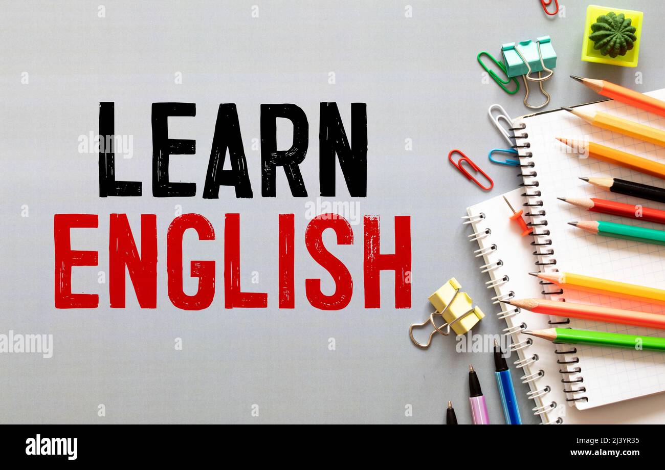 Learn English Text written on notebook page, red pencil and coffee cup ...