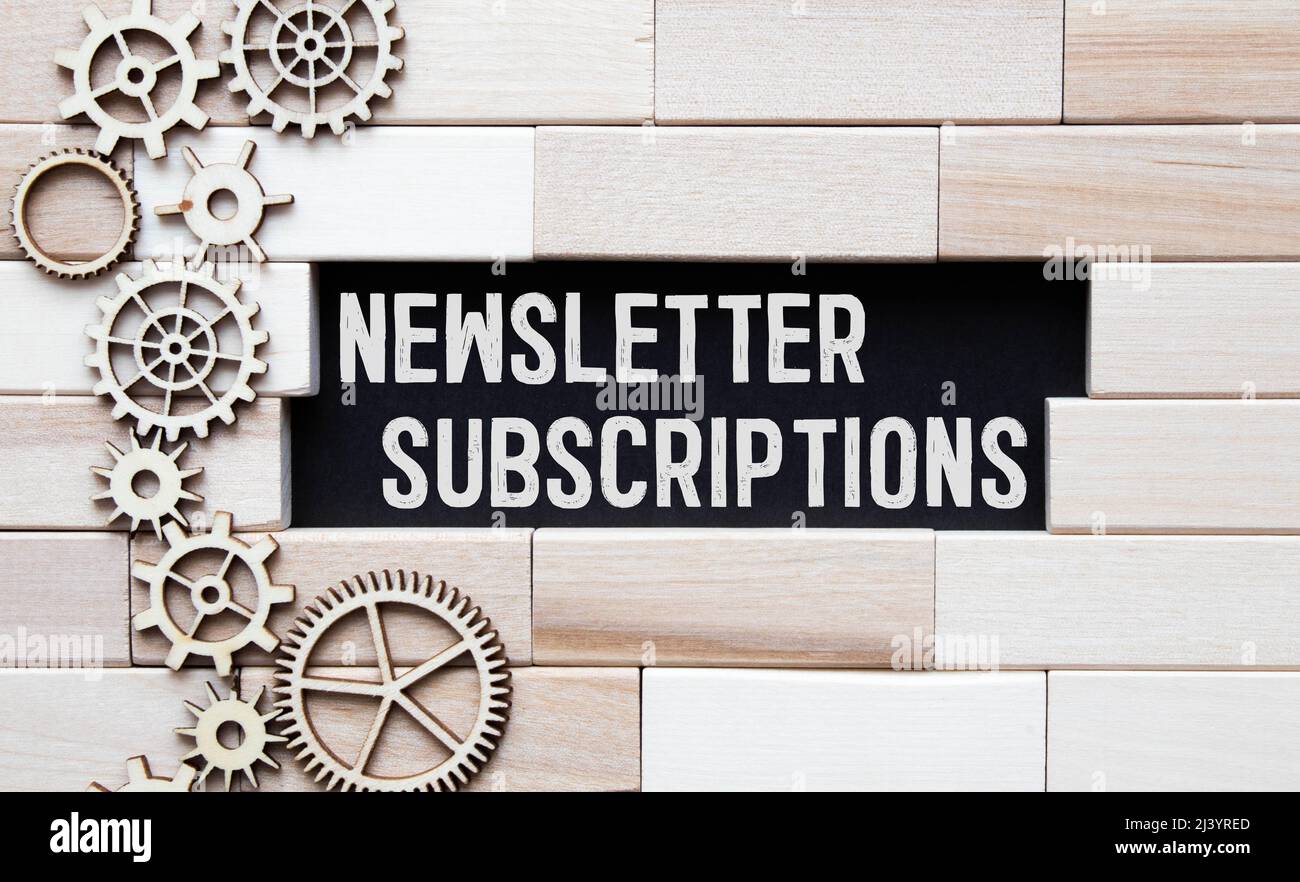 The words SUBSCRIBE NOW is written in a white notepad near a white cup ...