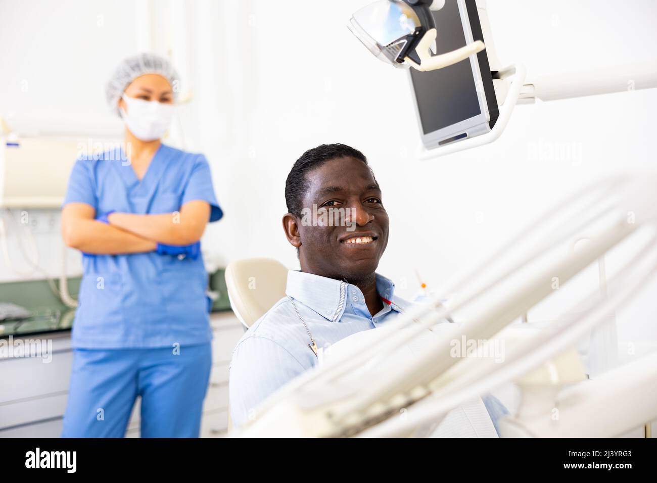Cheerful African American after dental procedure in dentist office ...