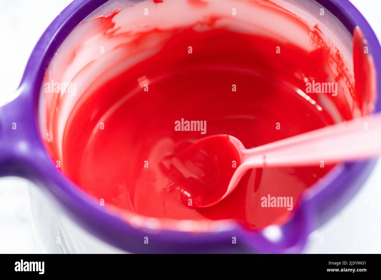 Melting red chocolate melts in the candy melting pot Stock Photo - Alamy
