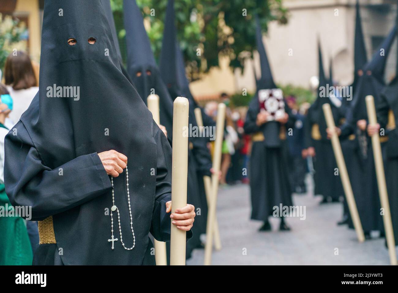 A Nazarenes seen holding a rosary during the procession of the students ...