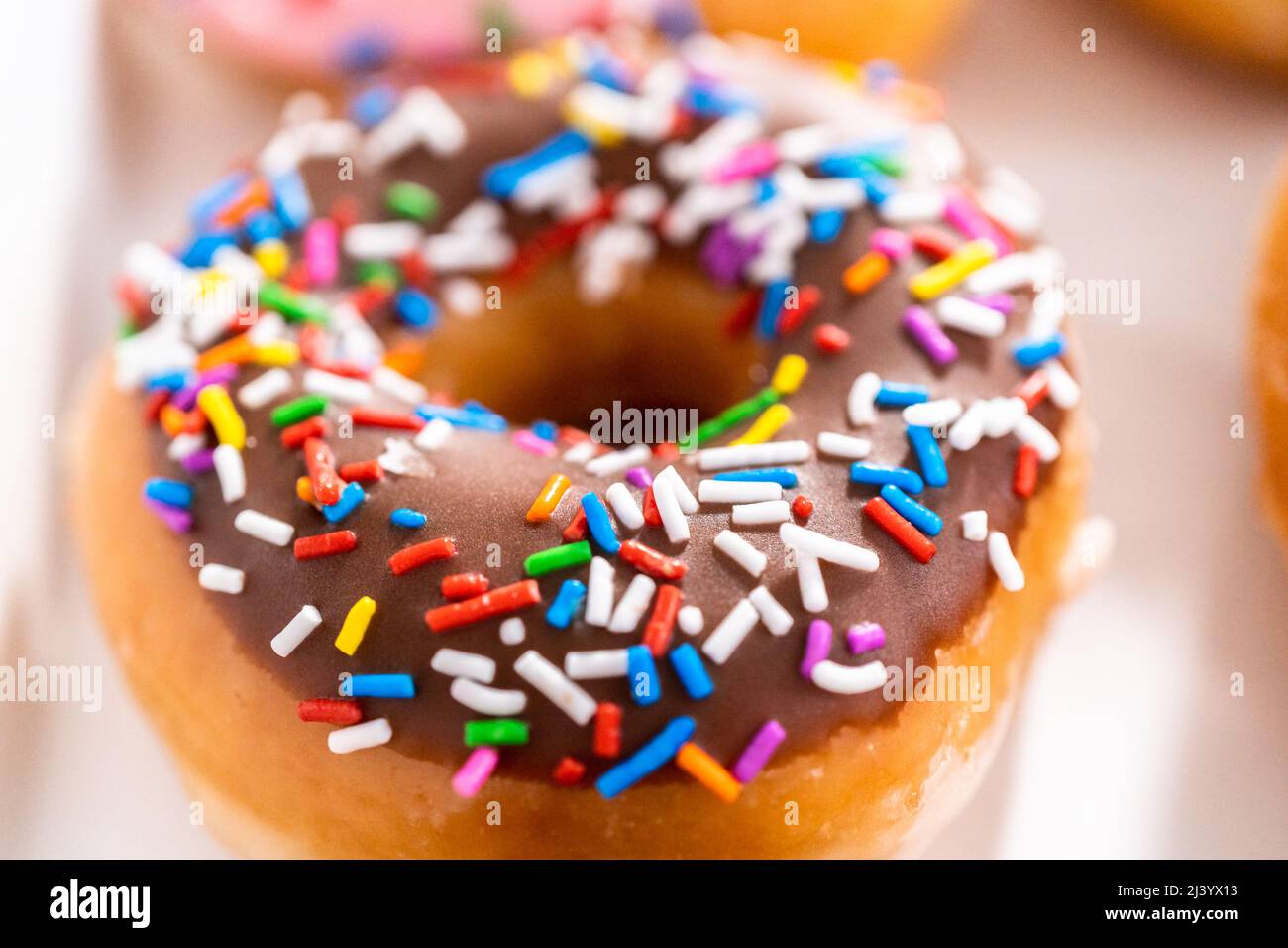 Variety of store-bought doughnuts in a white paper box Stock Photo - Alamy
