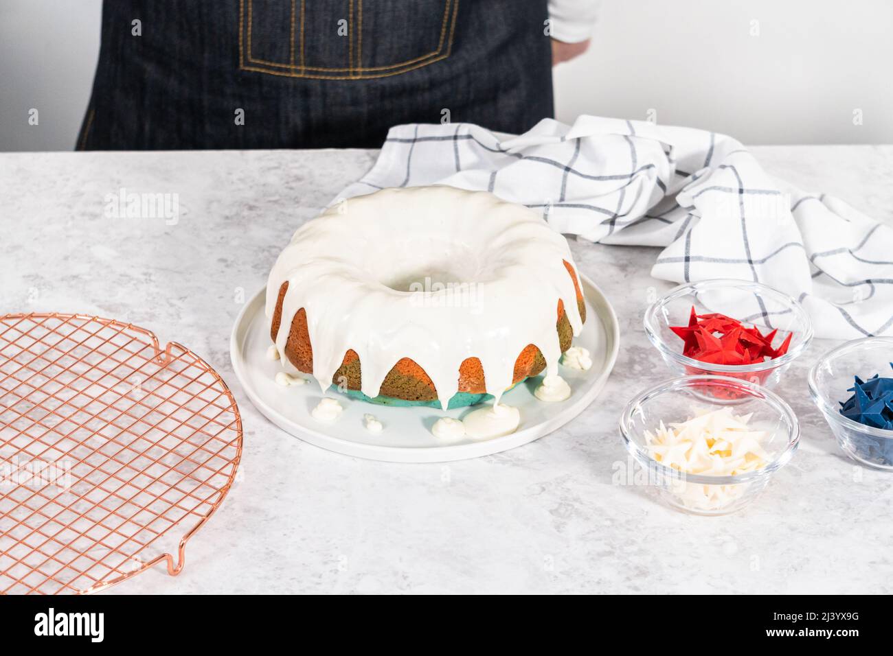 Glazing freshly baked bundt cake with vanilla glaze Stock Photo - Alamy