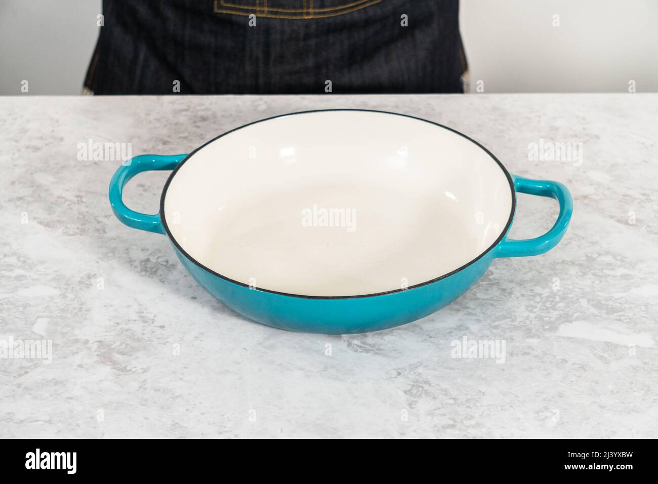 Clean cast iron enameled braiser on the kitchen counter Stock Photo - Alamy