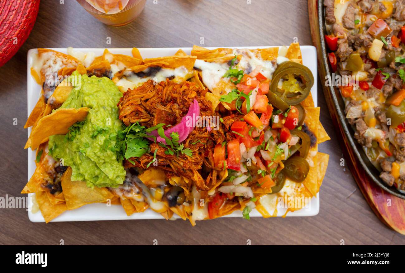 Nachos with meat, vegetables and Guacamole Stock Photo - Alamy
