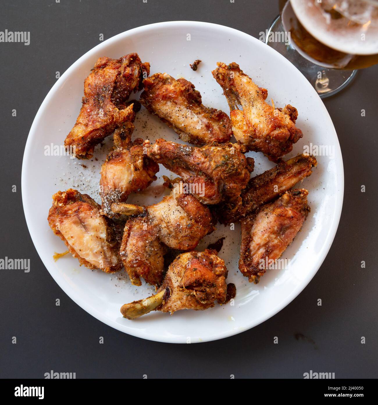 Tasty crispy grilled chicken wings on plate Stock Photo - Alamy