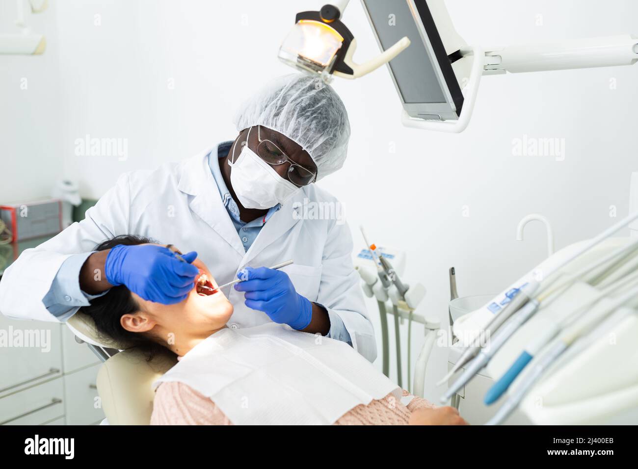Doctor dentist showing woman patient x-ray of teeth on computer Stock ...