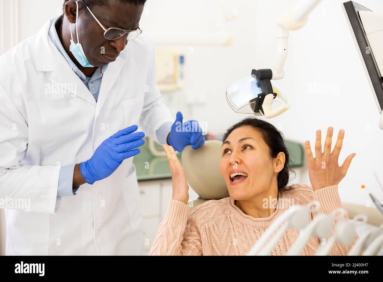 Asian woman with toothache sitting in chair at dentist appointment ...