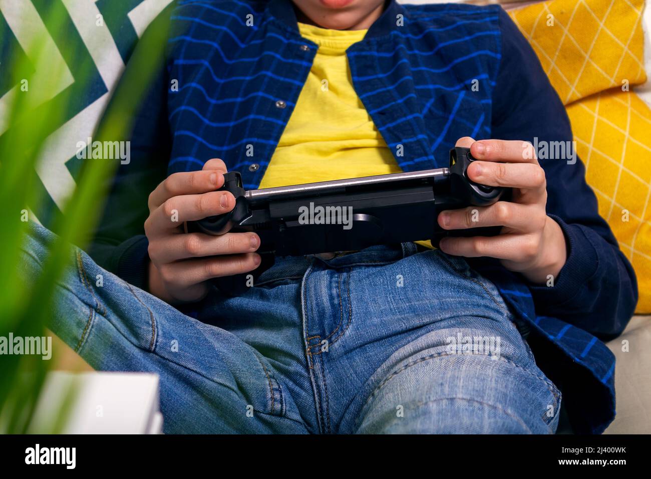 Teenager playing on his phone with console Stock Photo - Alamy