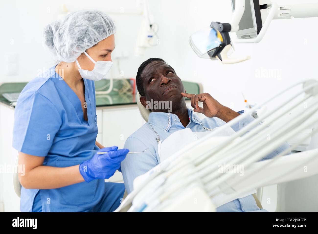 Patient complaining to doctor dentist about toothache Stock Photo - Alamy