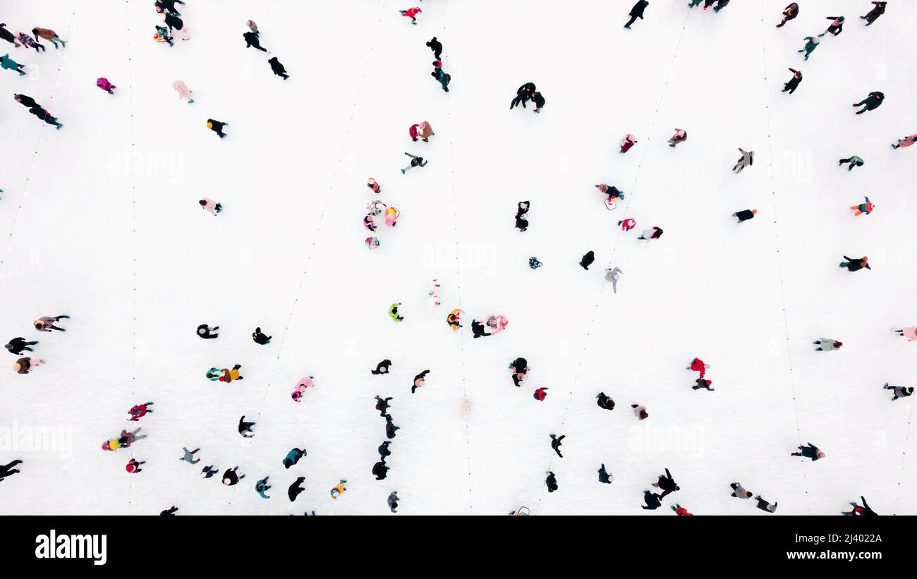 Aerial Drone View Over many people skating on an open-air ice rink in ...
