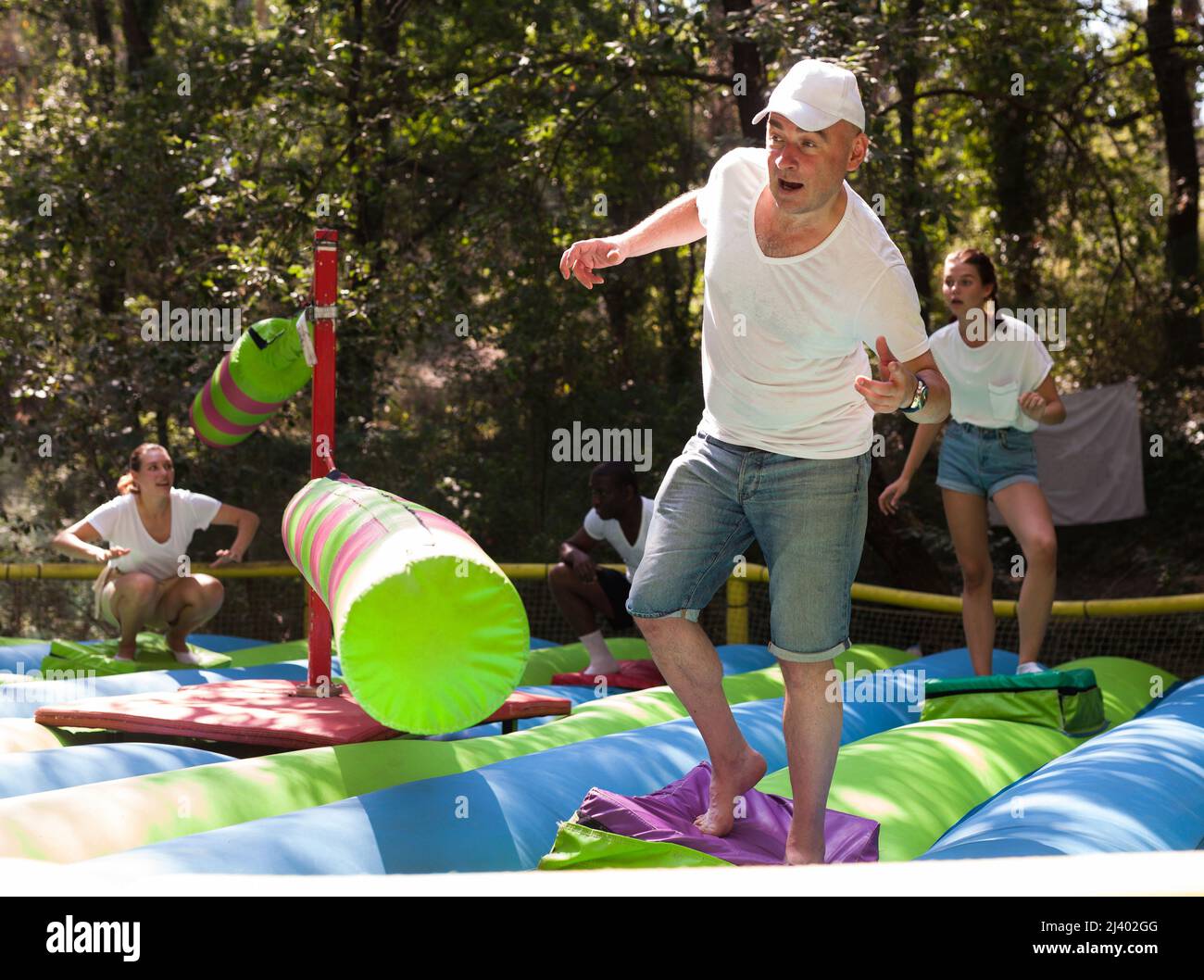 Funny adult friends are jumping on an inflatable trampoline Stock Photo ...