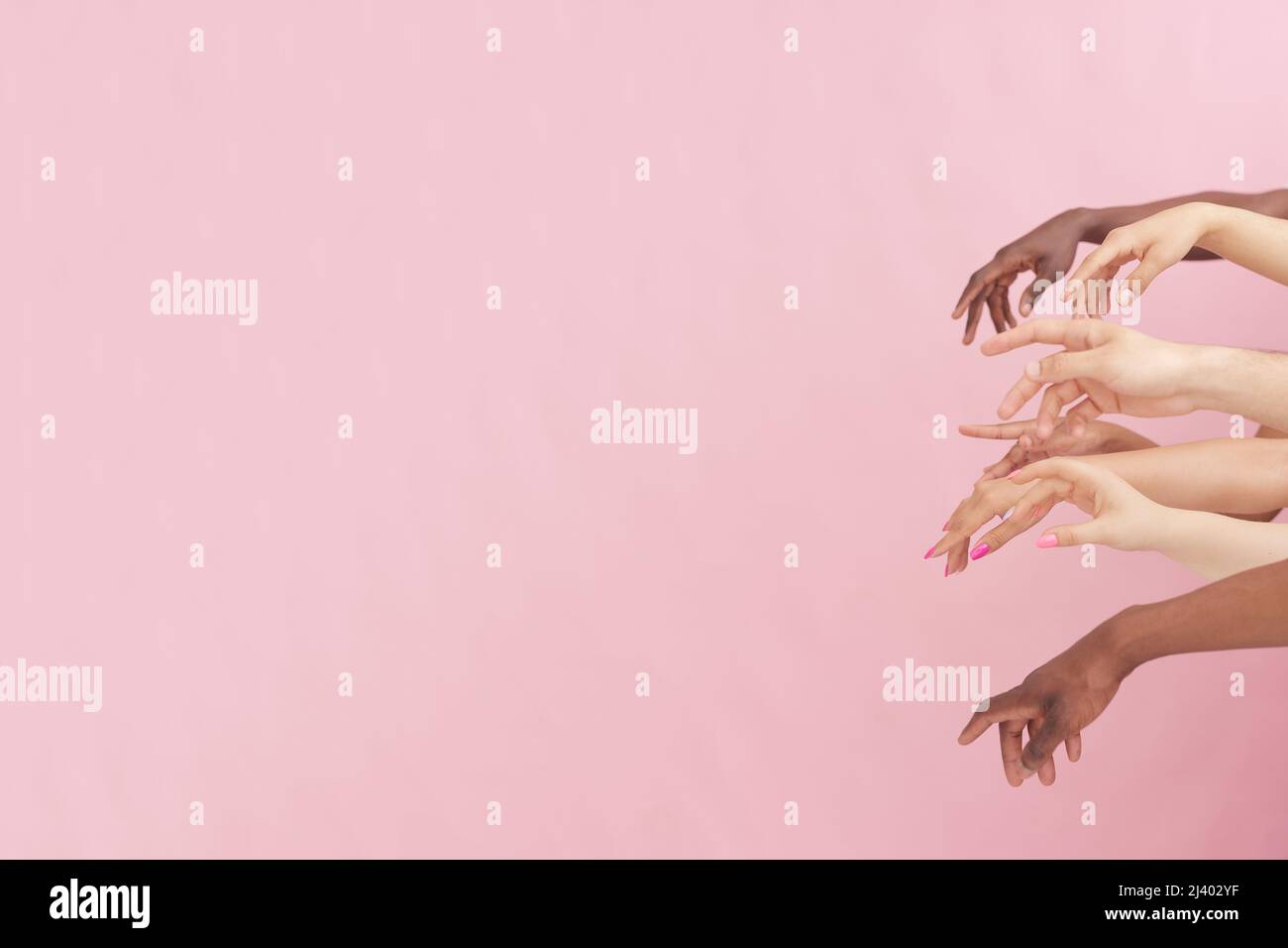 Art. African American and Caucasian hands showing on pink studio ...