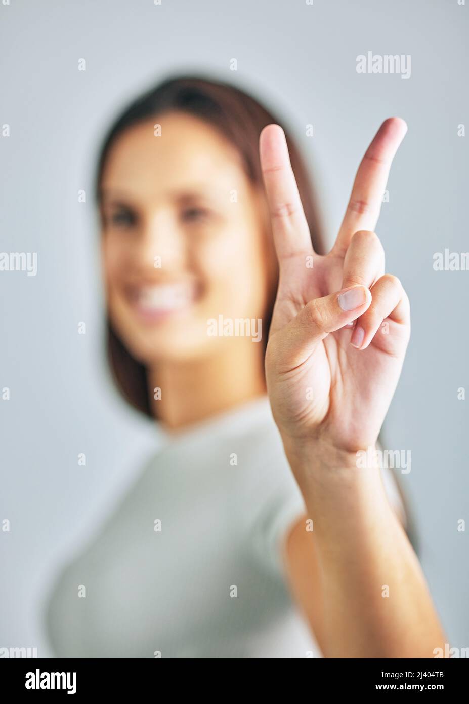 Positive vibes only. Studio shot of a young woman showing the peace ...