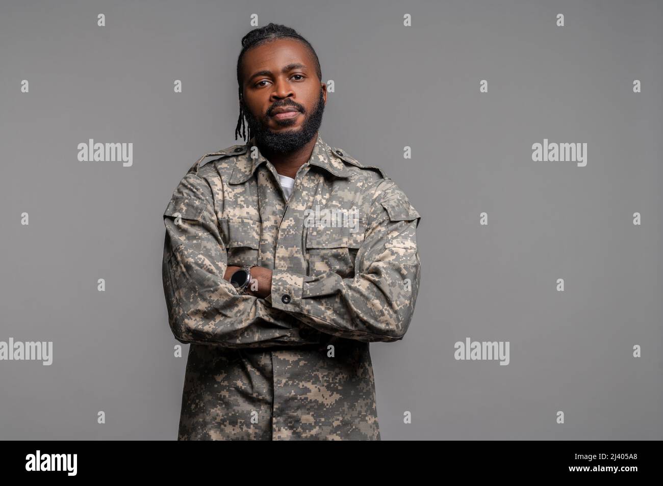 Front view of a calm military man with his arms crossed looking before ...