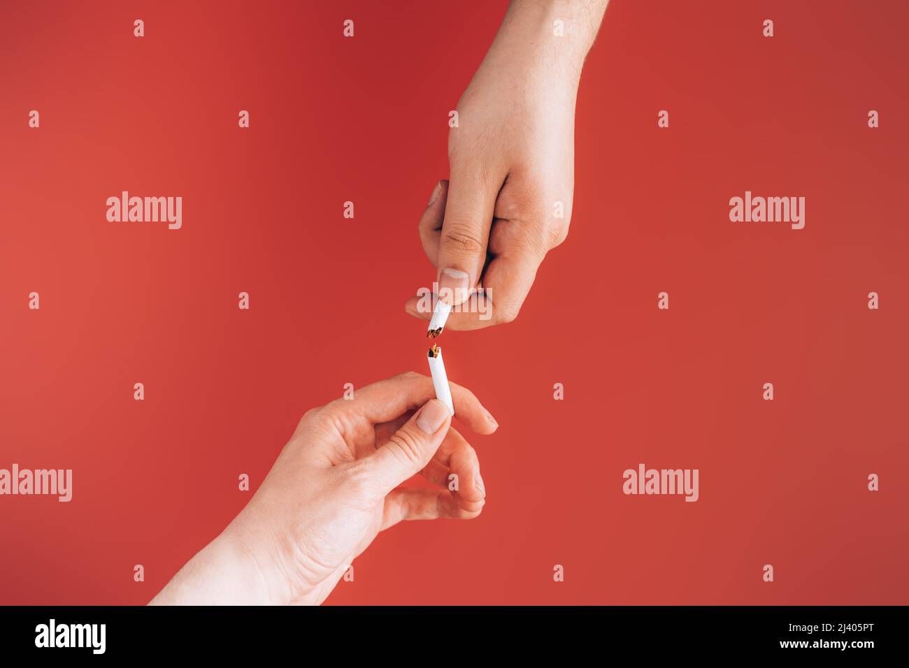 One person takes cigarette from another against red background Stock ...