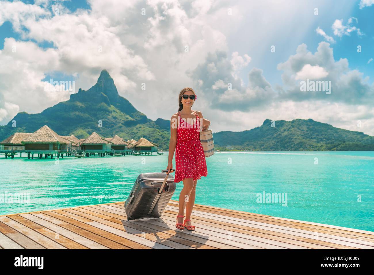 Hotel luxury resort tourist woman arriving with luggage suitcase in ...