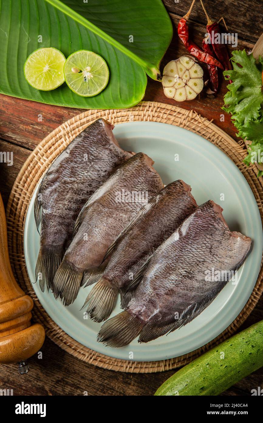 Fresh fish on the table garnished with vegetables Stock Photo - Alamy