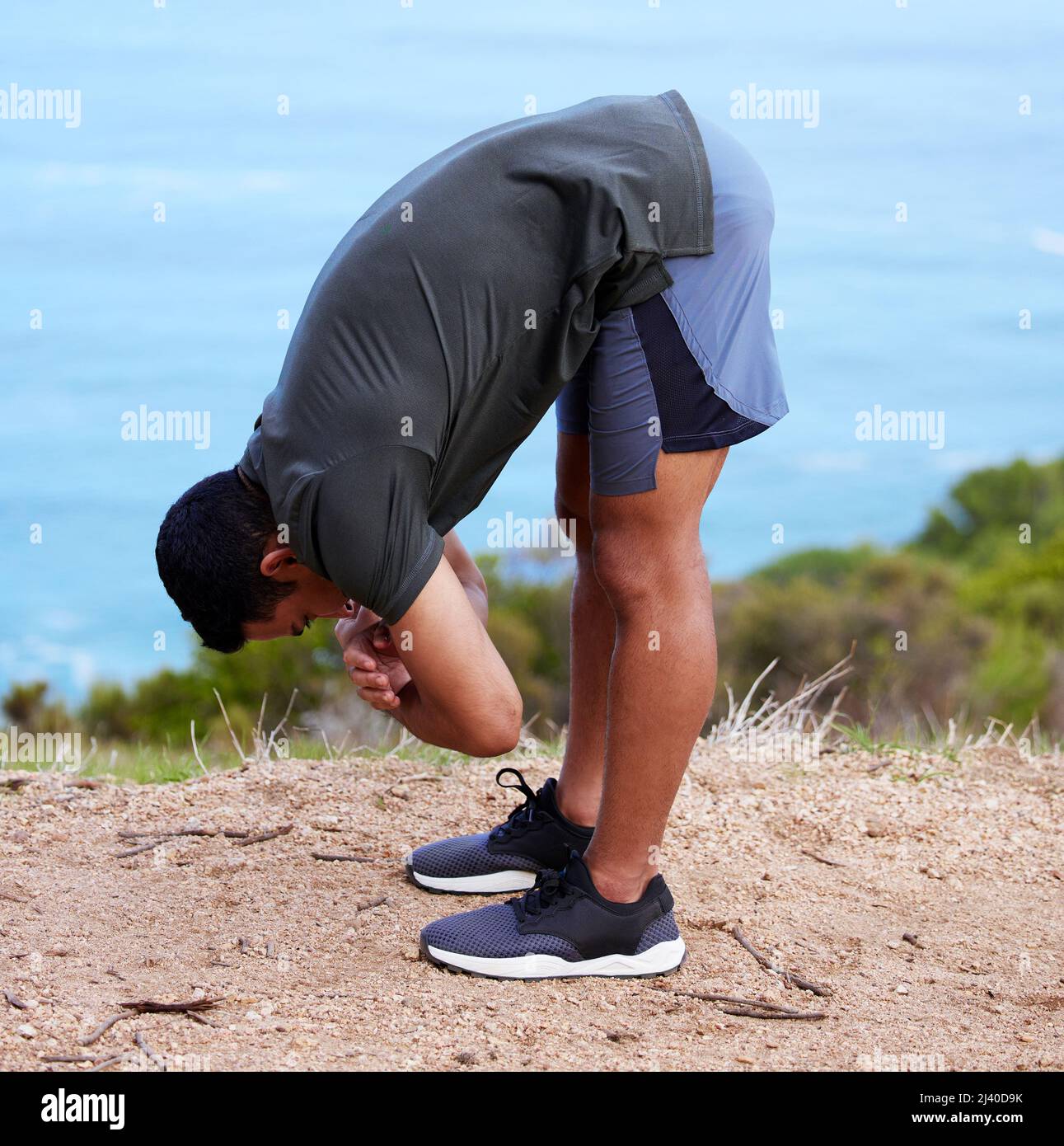 Working on improving his flexibility. Shot of a sporty young man ...