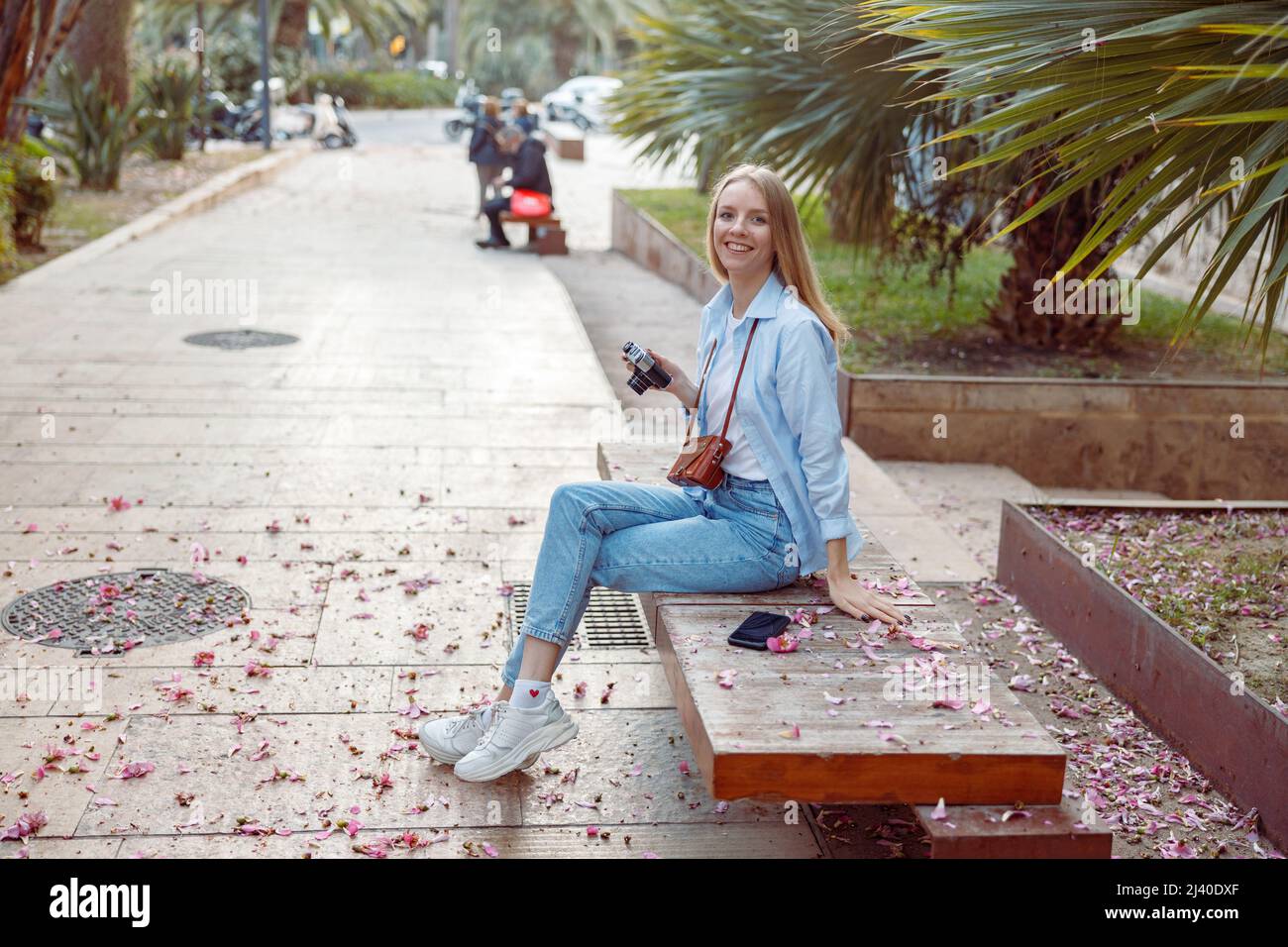 Charming young lady relaxing on bench outdoors Stock Photo - Alamy