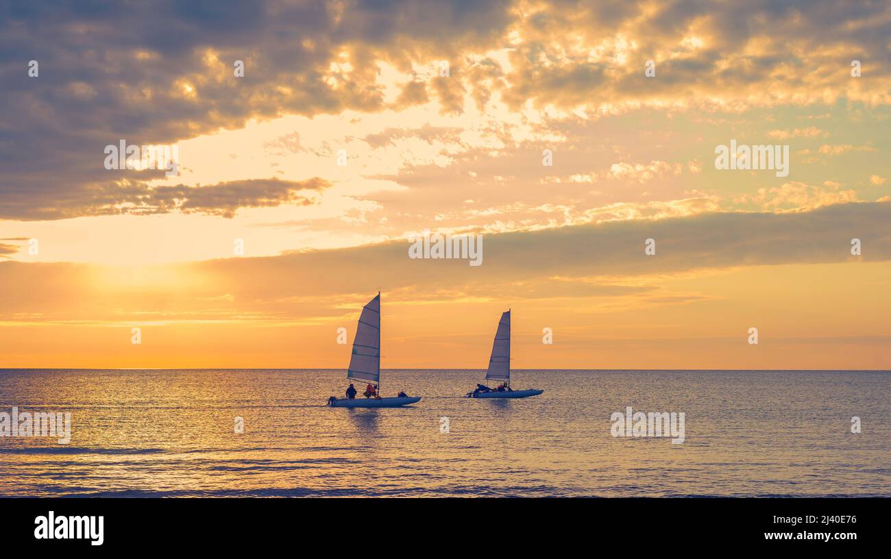 two sailboats in sunset sea Stock Photo - Alamy