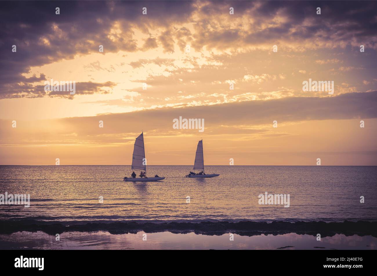 two sailboats in sunset sea Stock Photo - Alamy