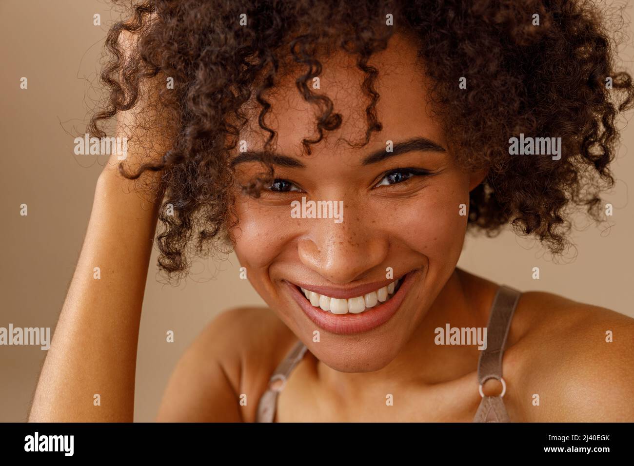 Happy young woman touching clean hair in studio interior Stock Photo ...