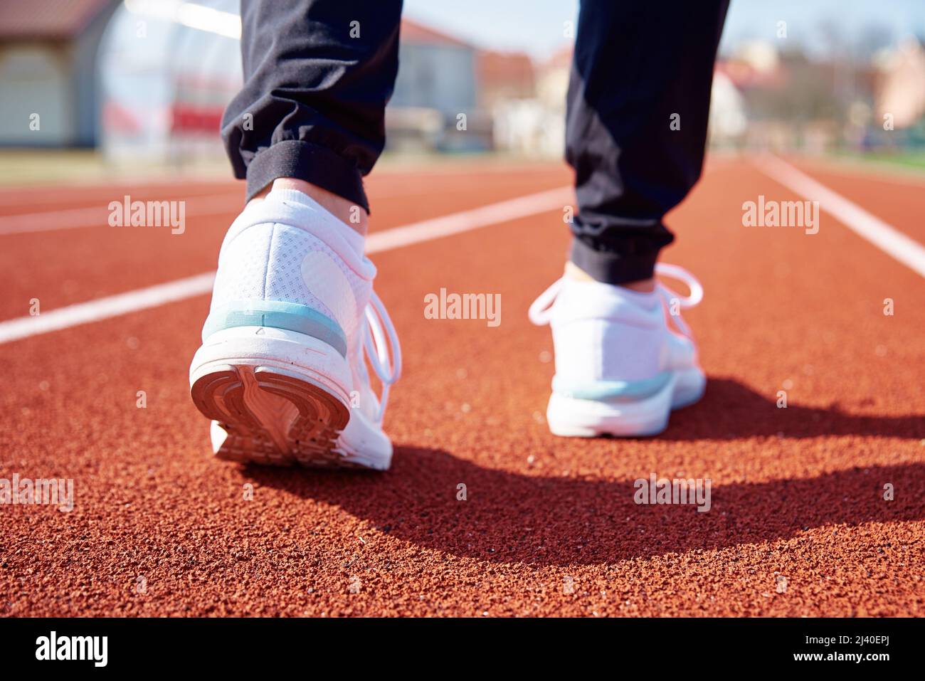 Male runner feet with white sneakers at stadium track, close up. Sport ...