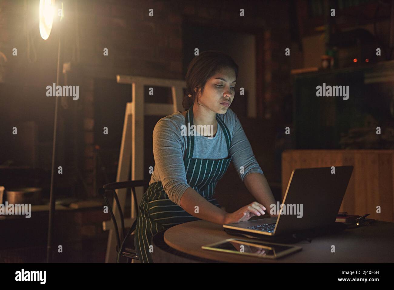 Working around the clock to maintain her business. Shot of a young ...