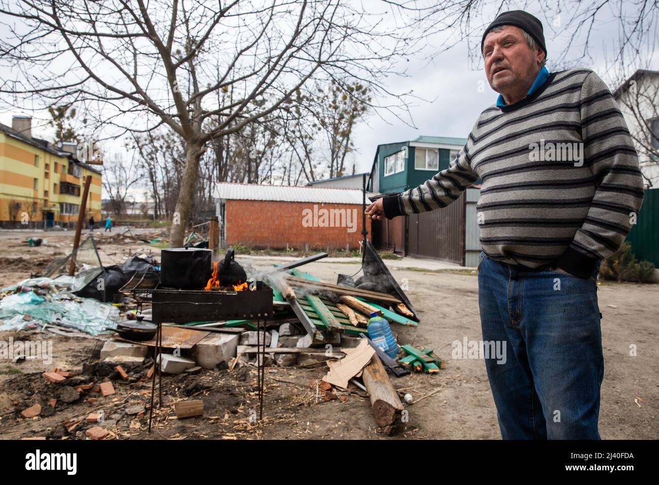 Bucha, Ukraine. 06th Apr, 2022. A man boils water and cooks food on the ...