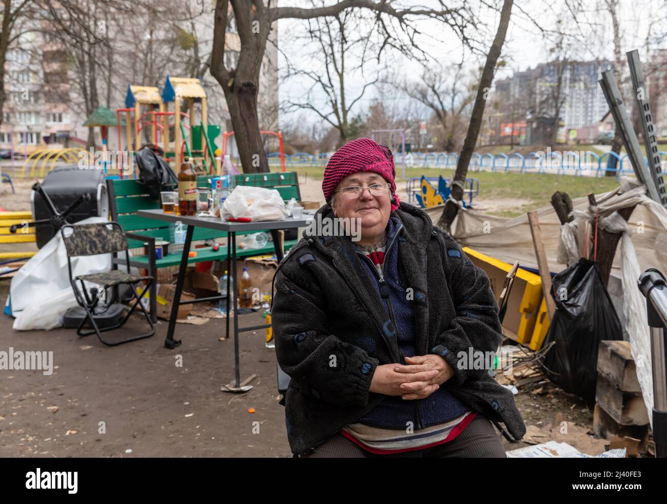 Bucha, Ukraine. 06th Apr, 2022. An elderly woman is sitting along a ...