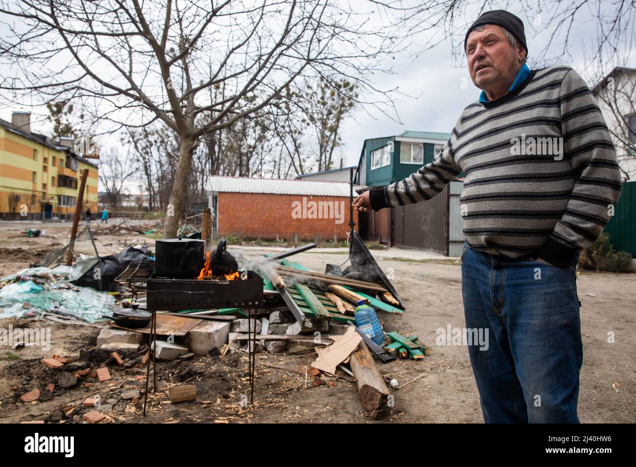 Bucha, Ukraine. 6th Apr, 2022. A man boils water and cooks food on the ...