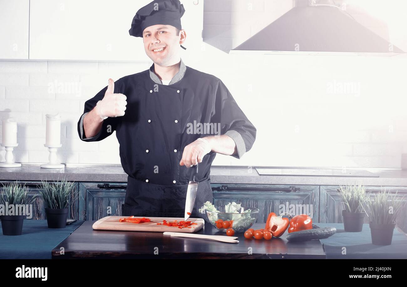 Man cook preparing food at the kitchen table of vegetables Stock Photo ...